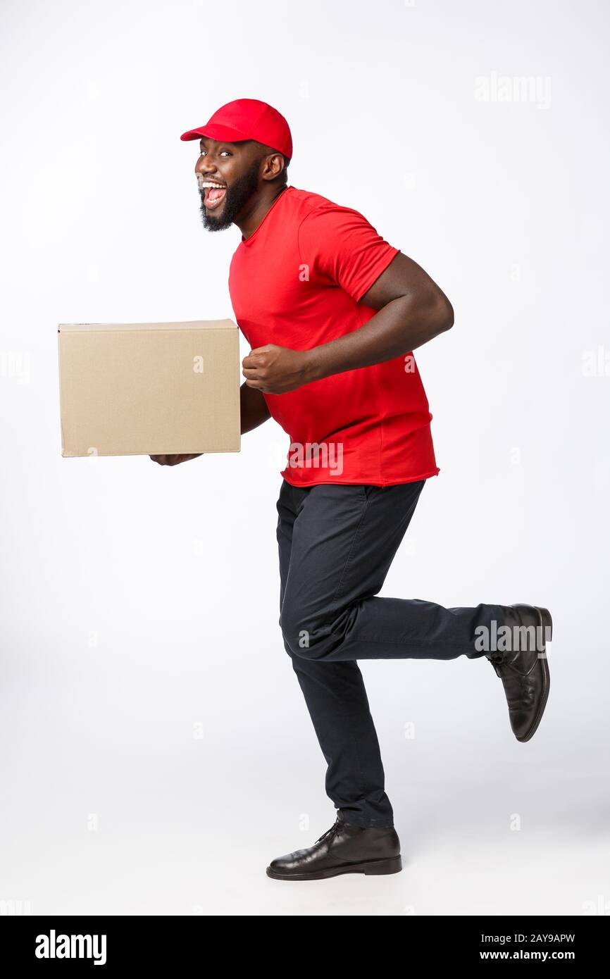 Portrait of Happy African American delivery man in red cloth walking to ...