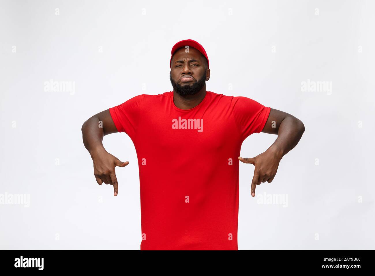 Portrait of handsome african american delivery man annoying pointing ...