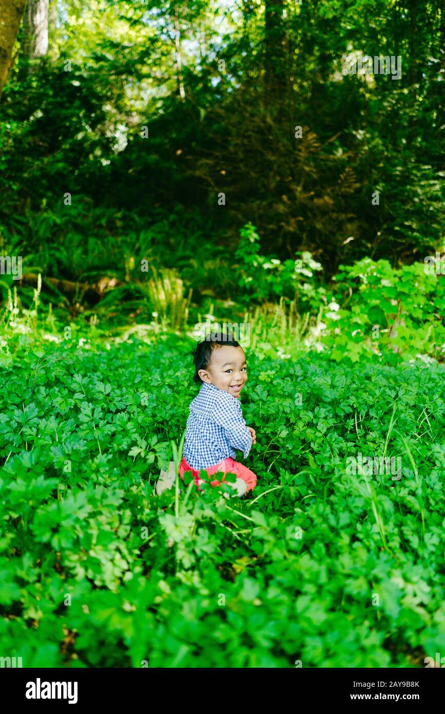Closeup portrait of a baby boy looking over his shoulder outdoors Stock ...