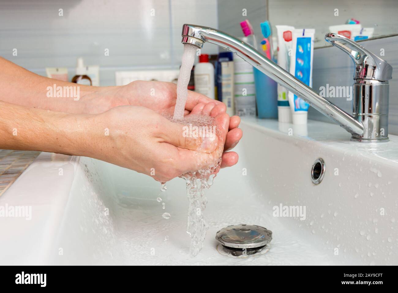 Hands under the tap from the mixer Stock Photo - Alamy