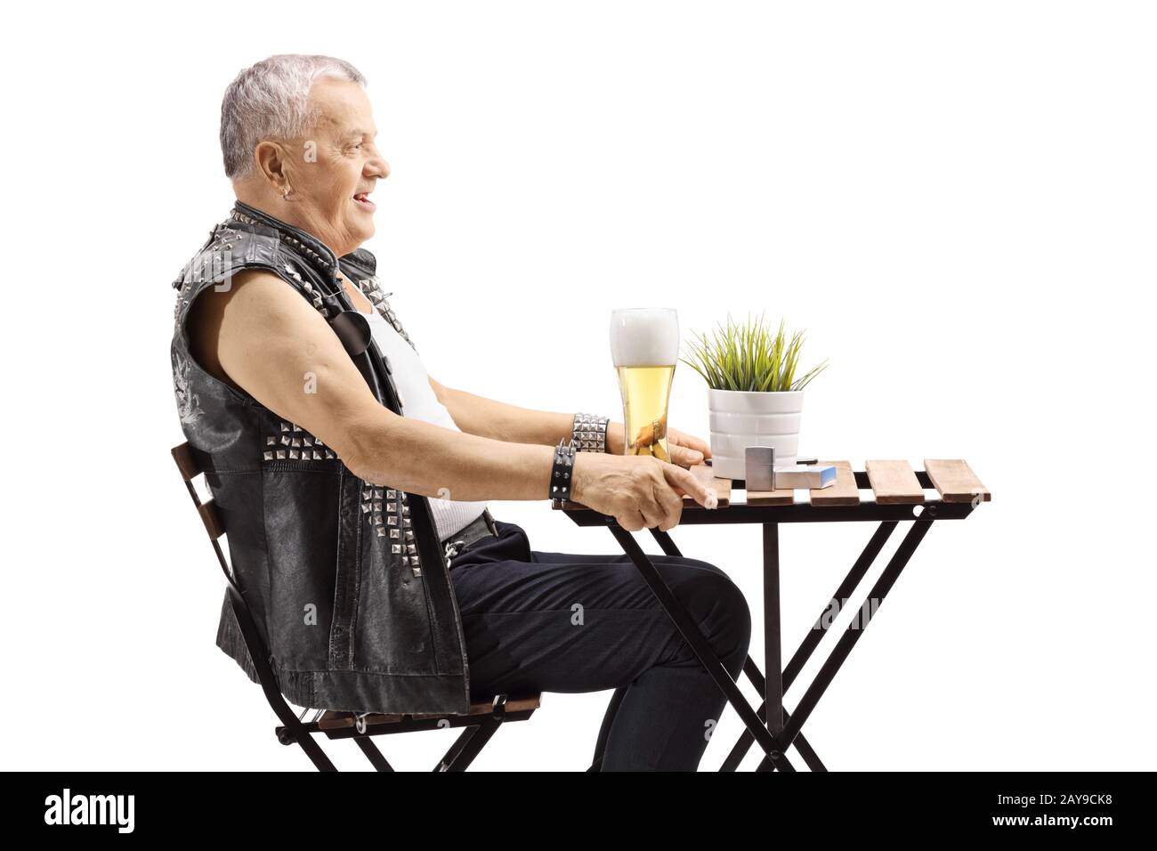 Mature punk sitting at a table with beer isolated on white background ...