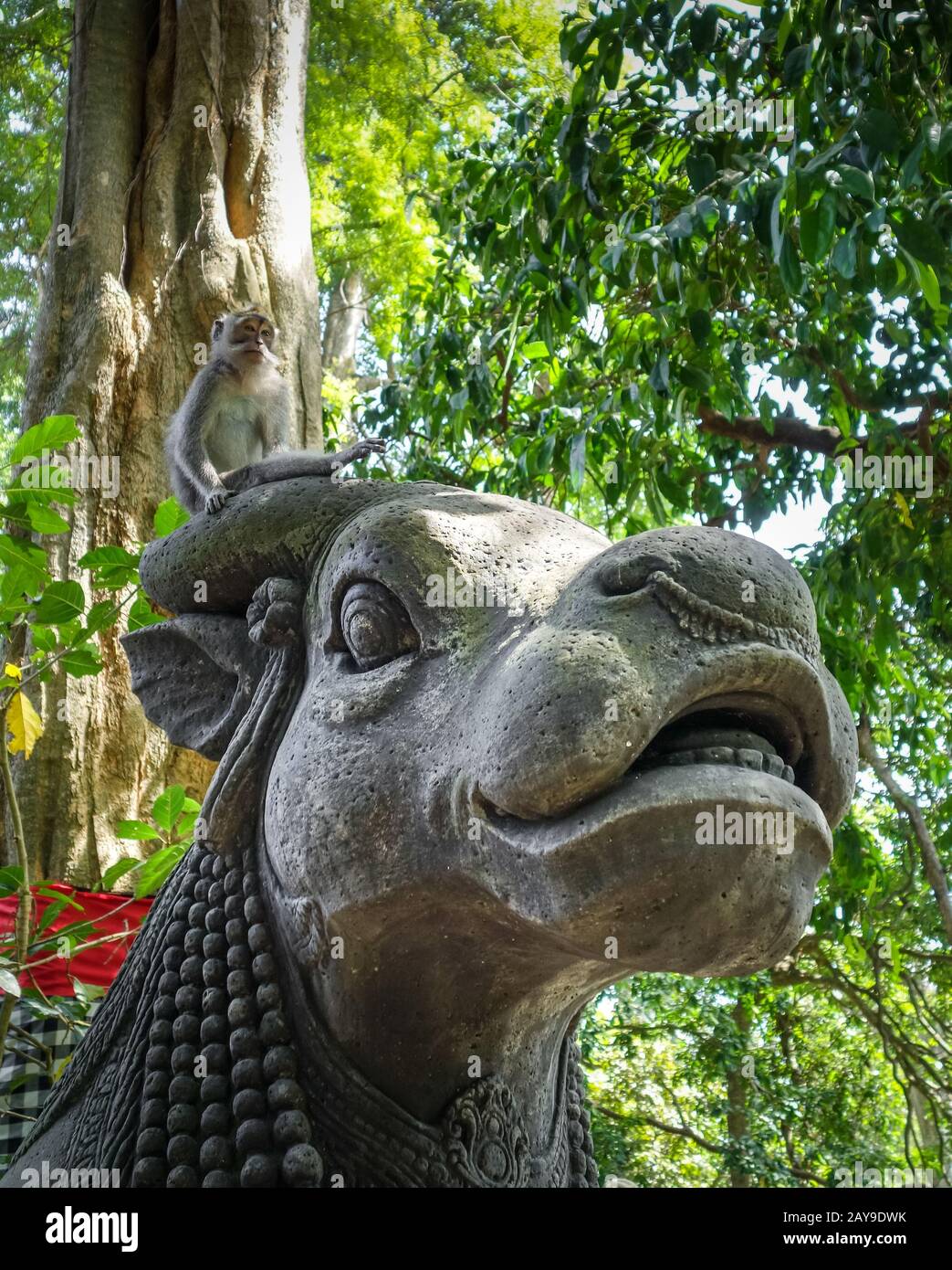 Monkey on a cow statue in the Monkey Forest, Ubud, Bali, Indonesia ...