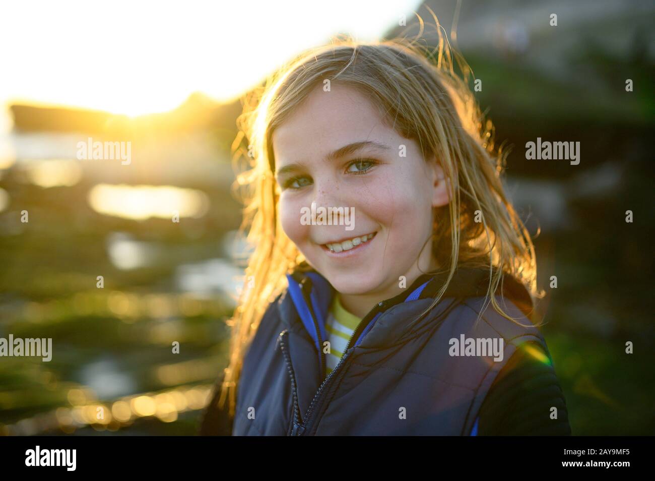Backlit sunset portrait of long haired boy smiling at the camera Stock ...