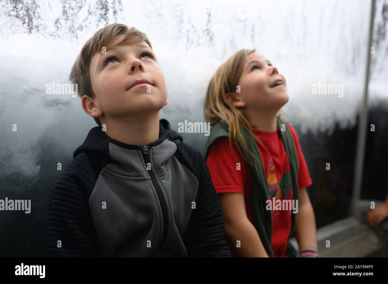 Two children seated looking up to the sky with curiosity Stock Photo ...