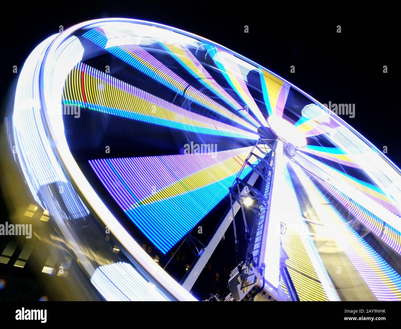 a long exposure motion blur of a spinning ferris wheel at night ...