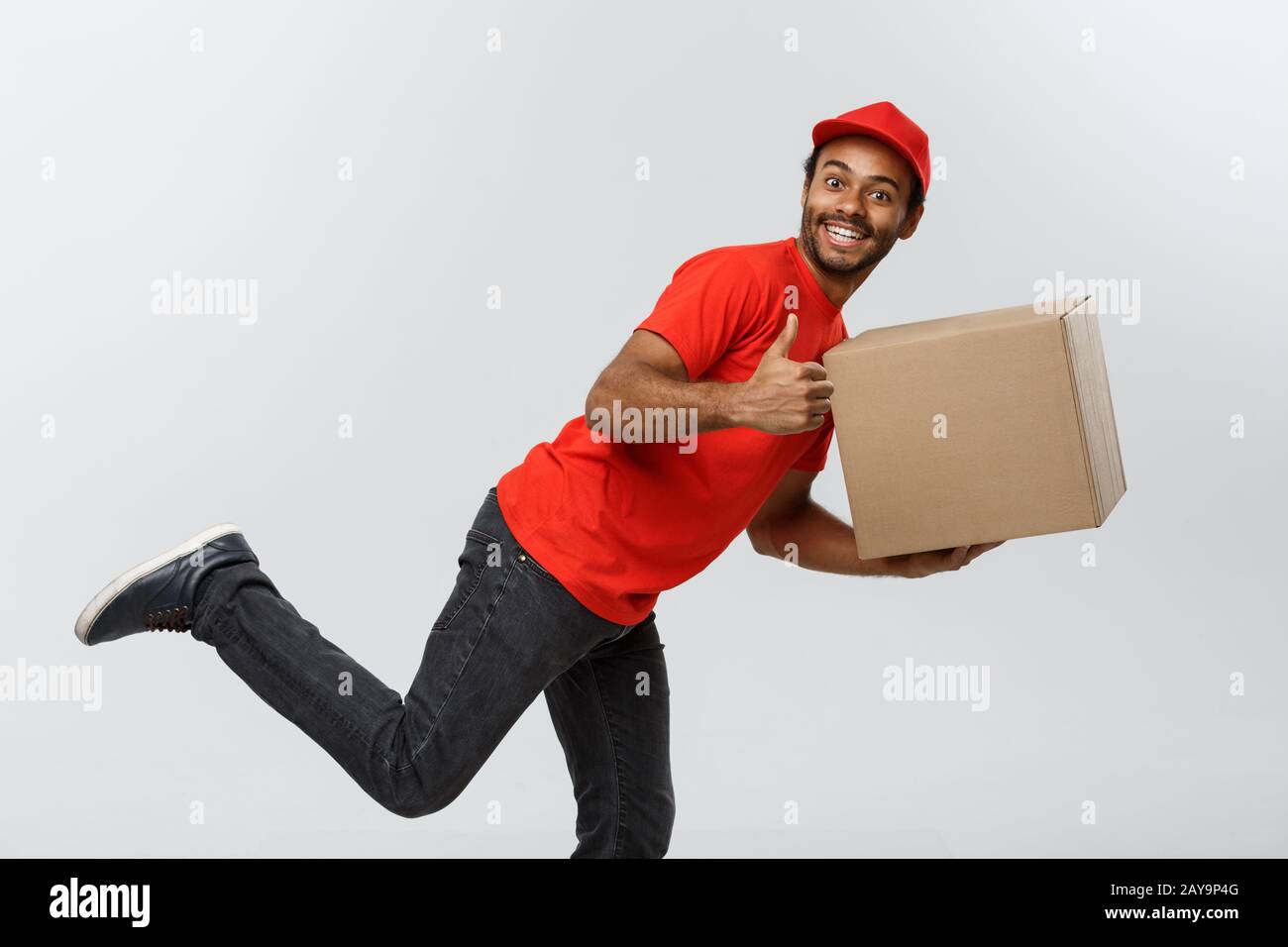 Delivery Concept - Handsome African American delivery man rush running ...