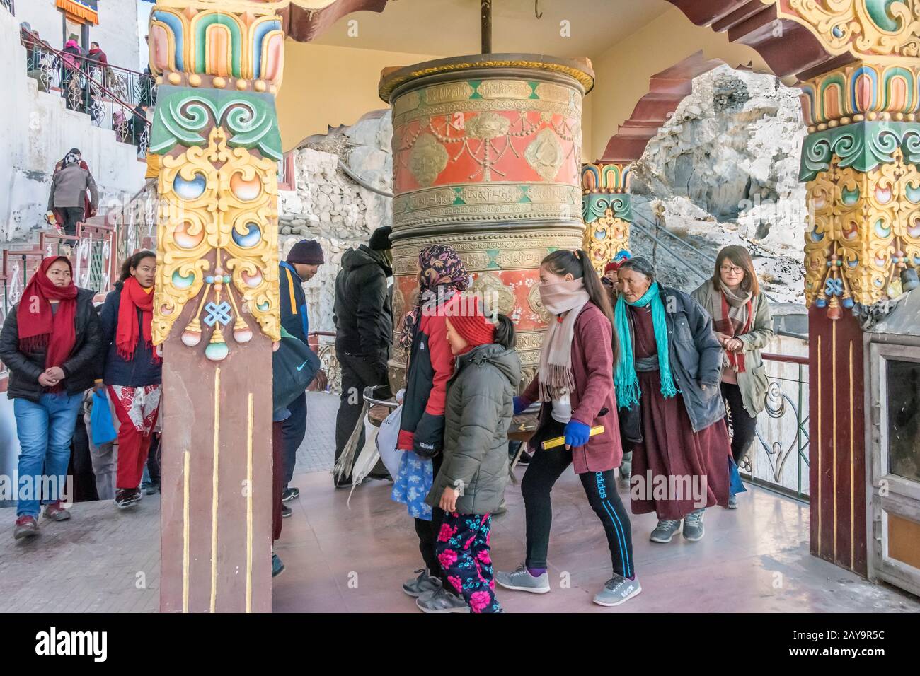 Spituk Gustor festival goers spinning a large prayer wheel, Spituk ...