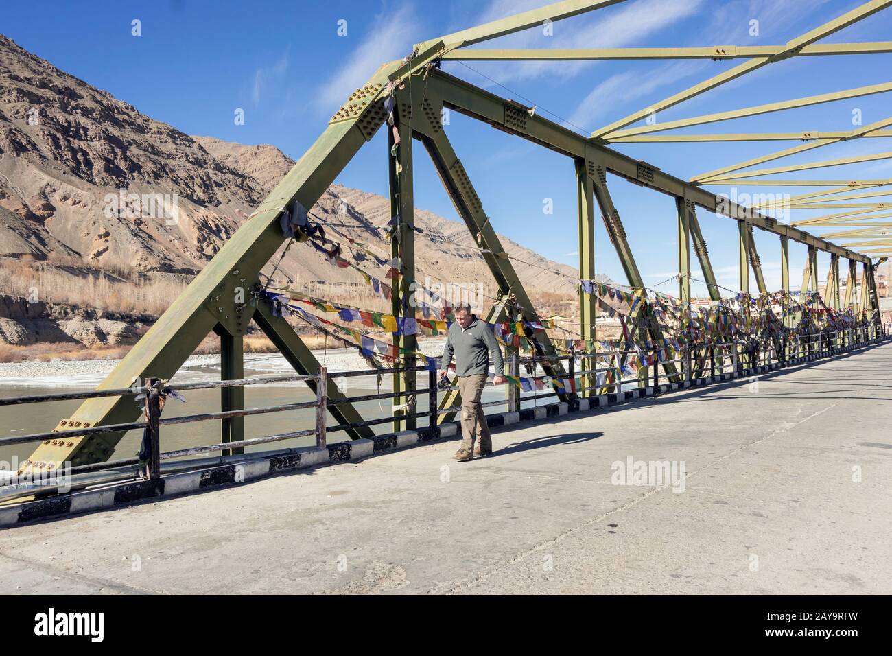 Man walking across the Upshi Bridge across the Indus River, festooned ...