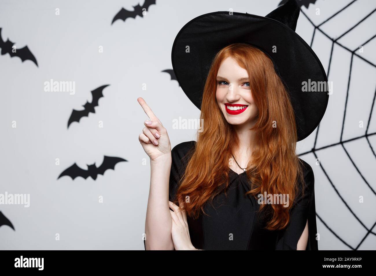 Halloween witch concept - Happy Halloween Witch pointing finger on side ...