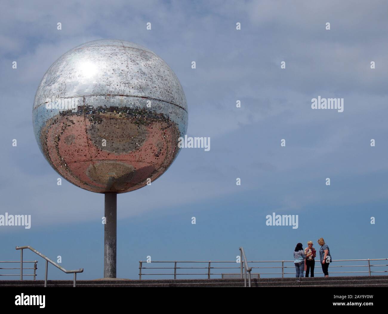 a group of women stood near the giant glitter ball on blackpool ...