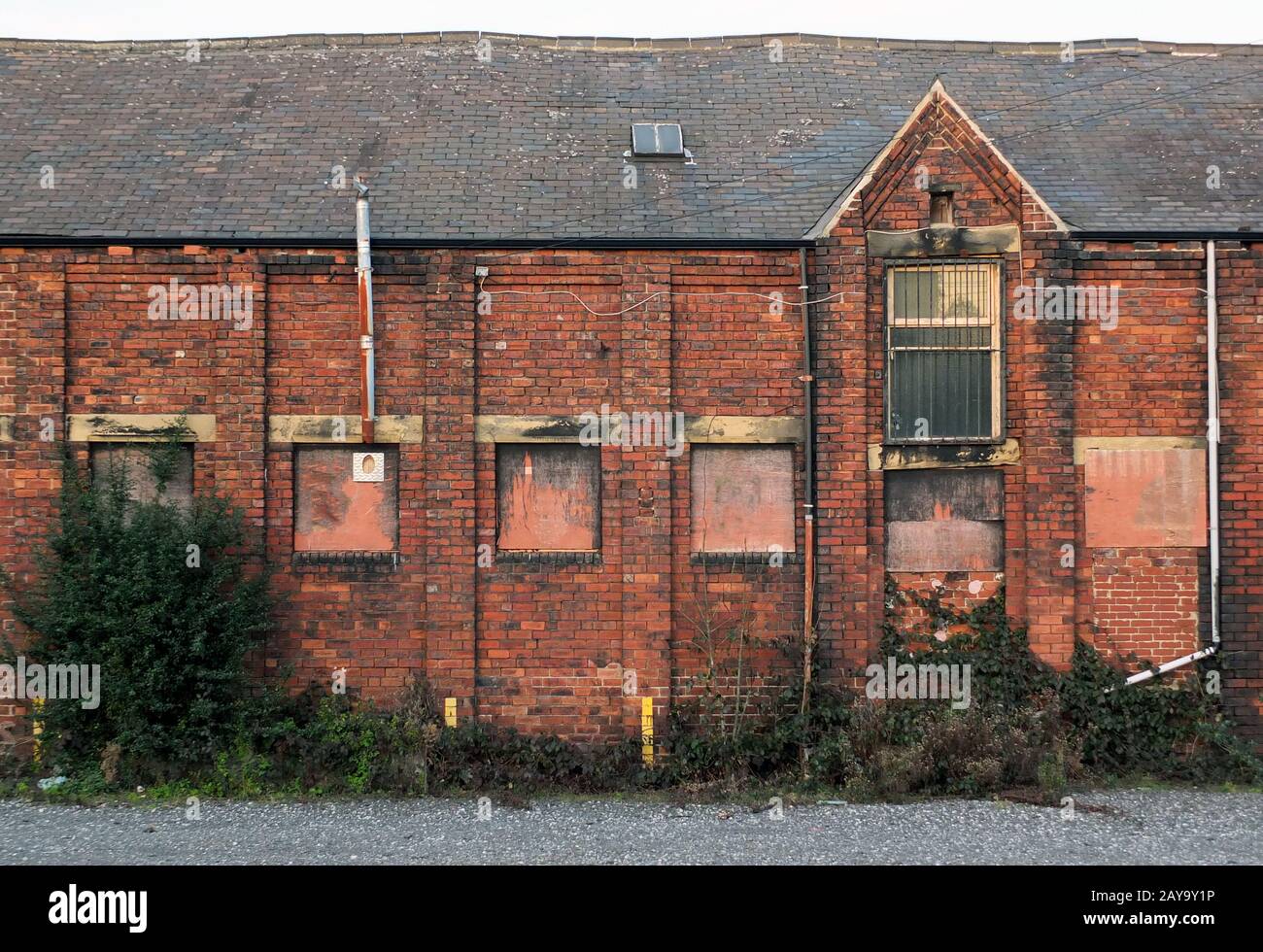 An old abandoned brick factory building with boarded up windows and ...