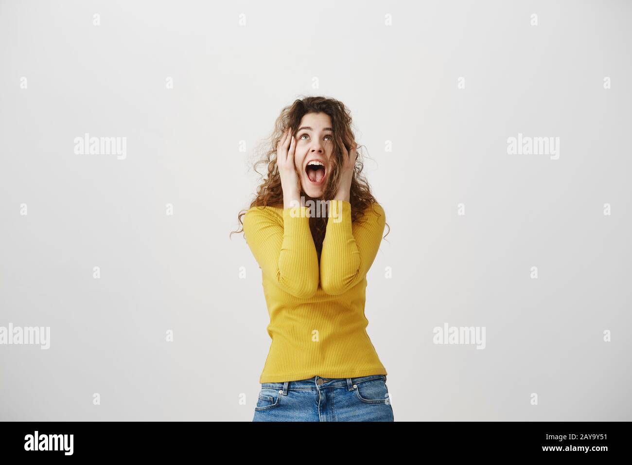 Portrait excited screaming young woman standing isolated over white ...