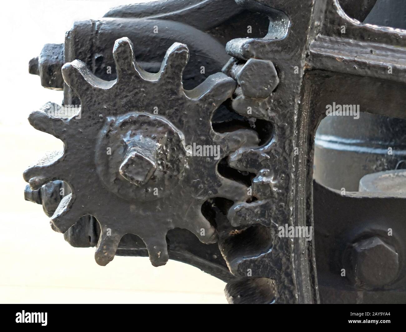 a close up of old worn black painted large cog wheels with gear teeth ...