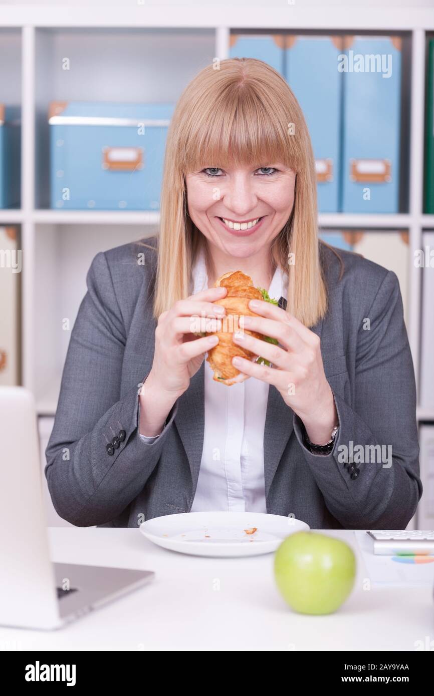 Woman at the office having lunch. Concept for healty or unhealthy food ...