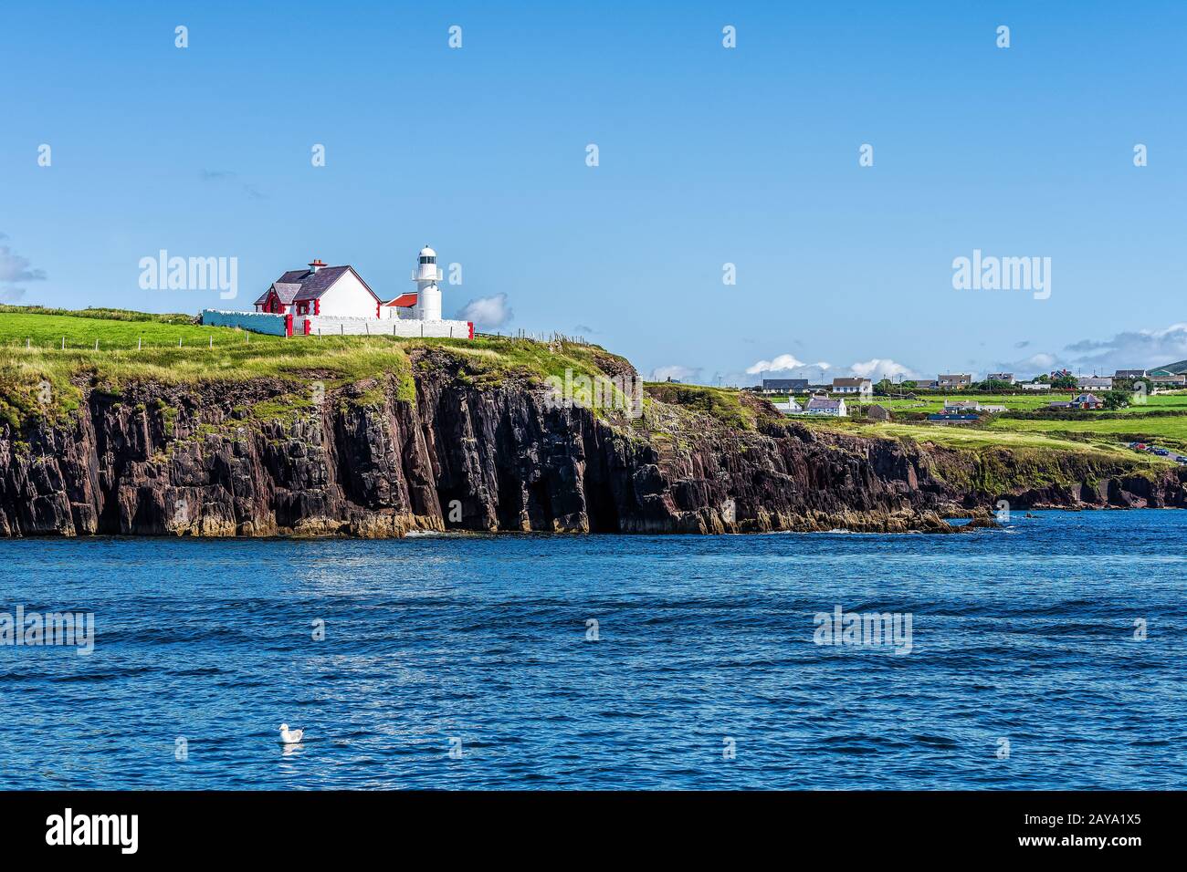 Lighthouse on the cliff with village in a distance Stock Photo - Alamy