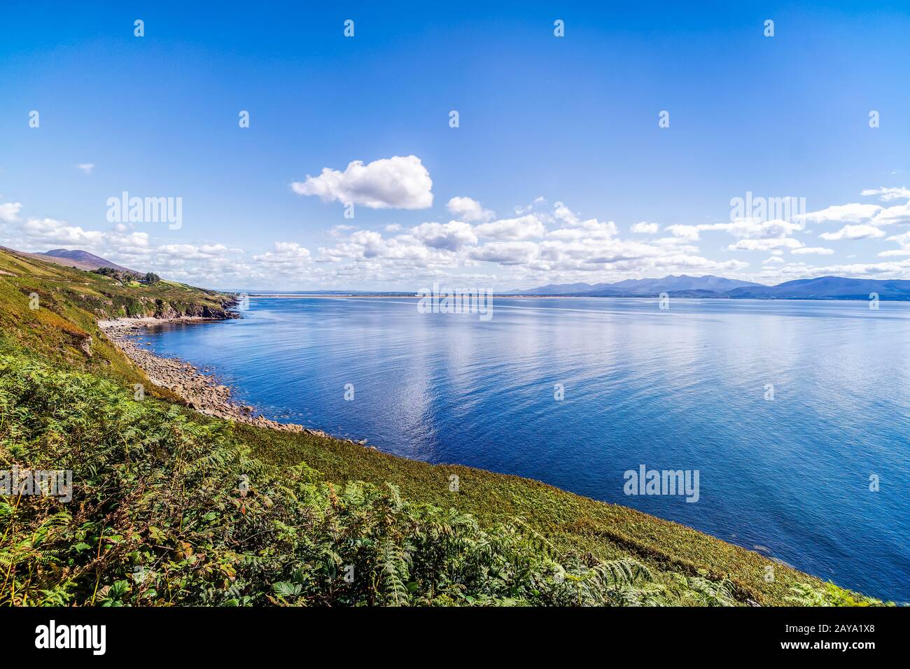 Rocky costal line and mountains in a distance with deep blue sky and ...