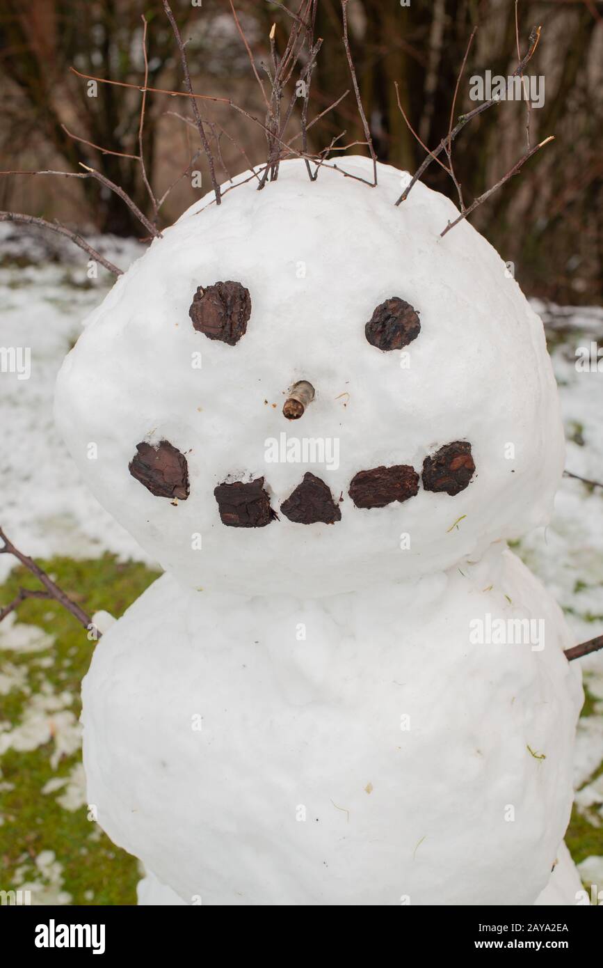 Snowman of children on a lawn built at the beginning of spring Stock ...