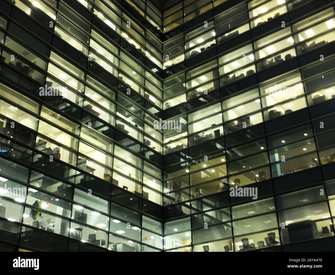 glowing illuminated windows in a large modern geometric office building ...
