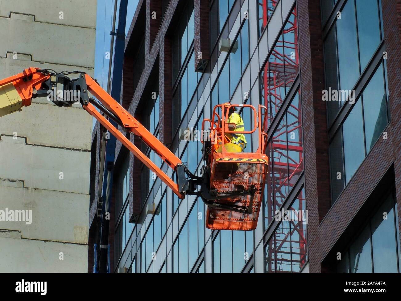 construction worker on an orange elevated platform on a large modern ...