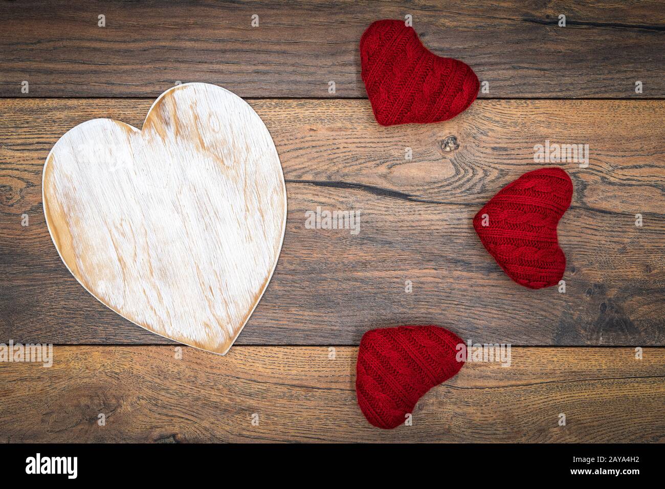 Large white wooden hart and three red cuddle hearts isolated on vintage ...