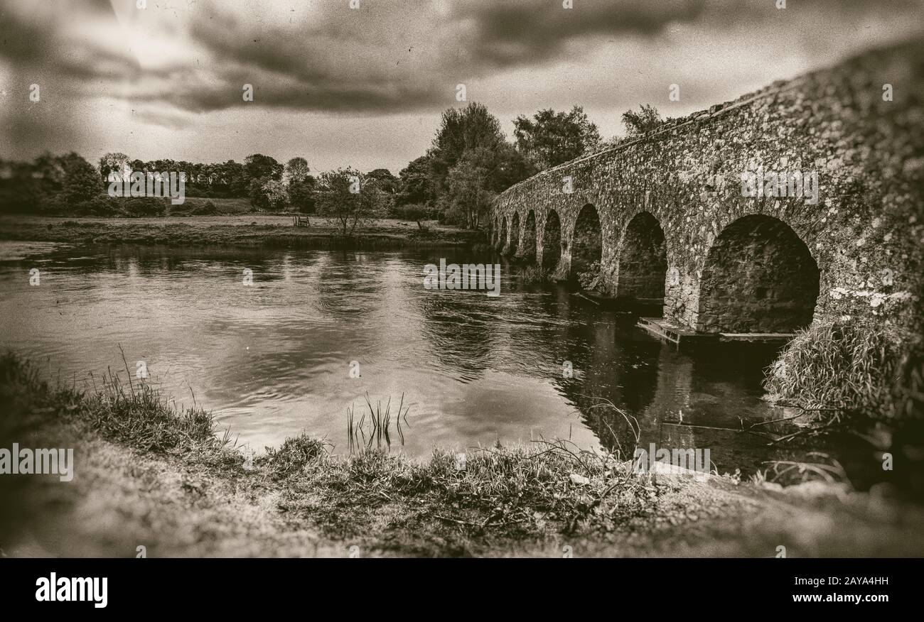 Old stone bridge with arches and moody sky Stock Photo - Alamy