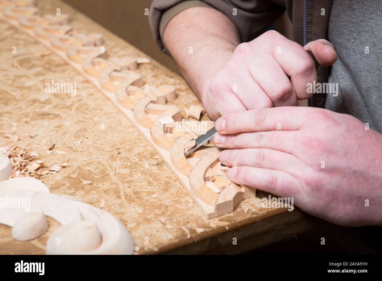 woodcarver creates a furniture ornament. Woodcarver's hands, chisels ...