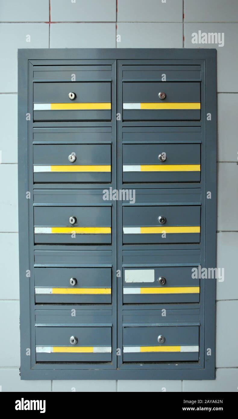 grey steel modern lockable mailboxes in a tiled exterior wall with ...