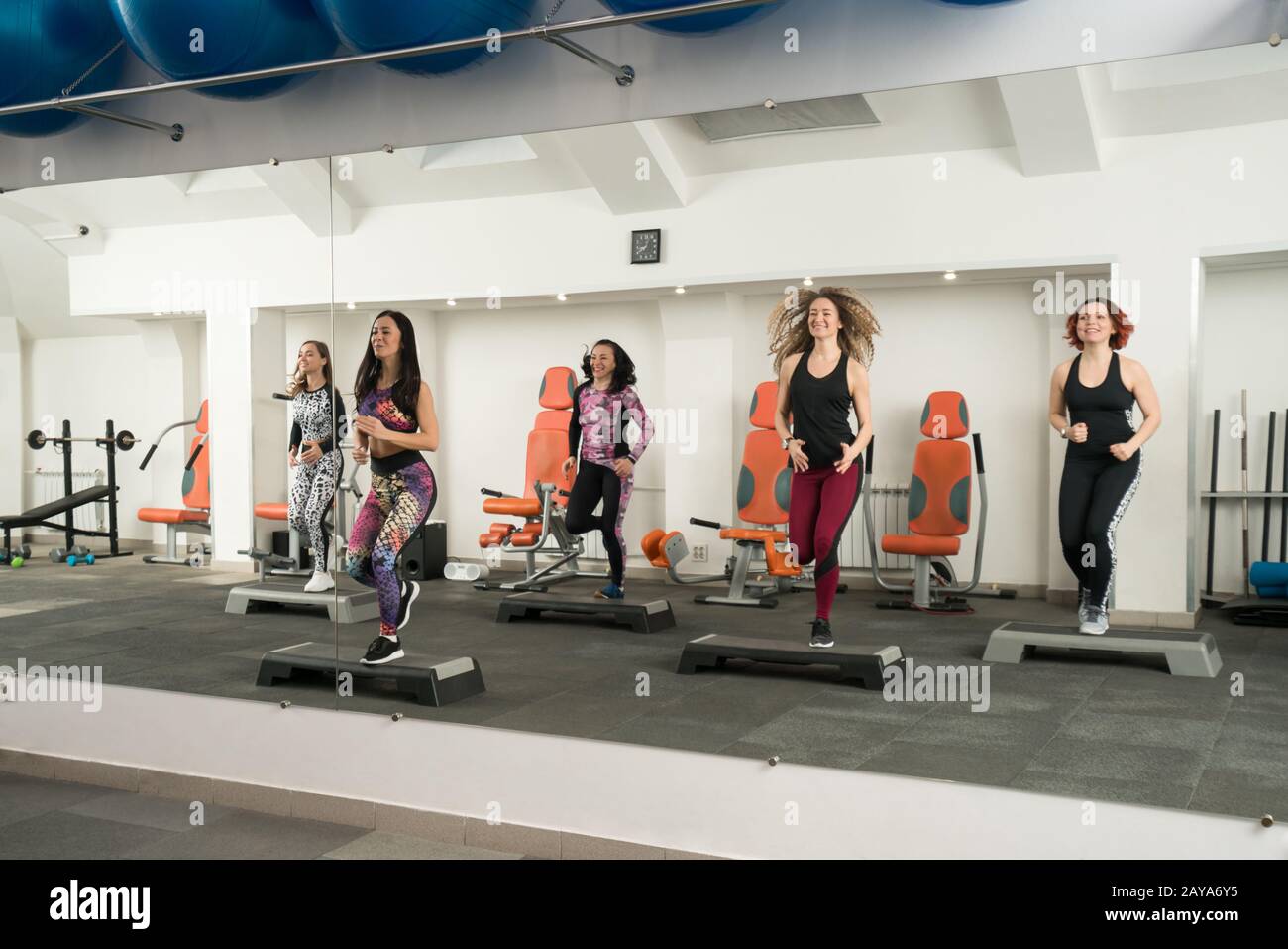 Young women exercising on step platforms in a gym Stock Photo - Alamy