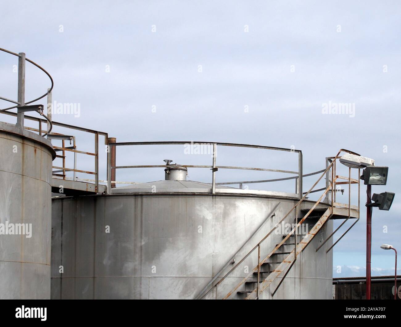 the top of large old silver steel industrial storage tanks with control ...