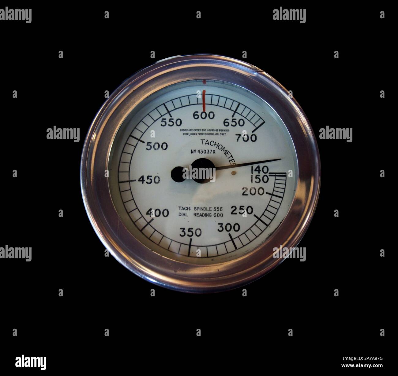 an old round metal industrial tachometer on a black background with ...