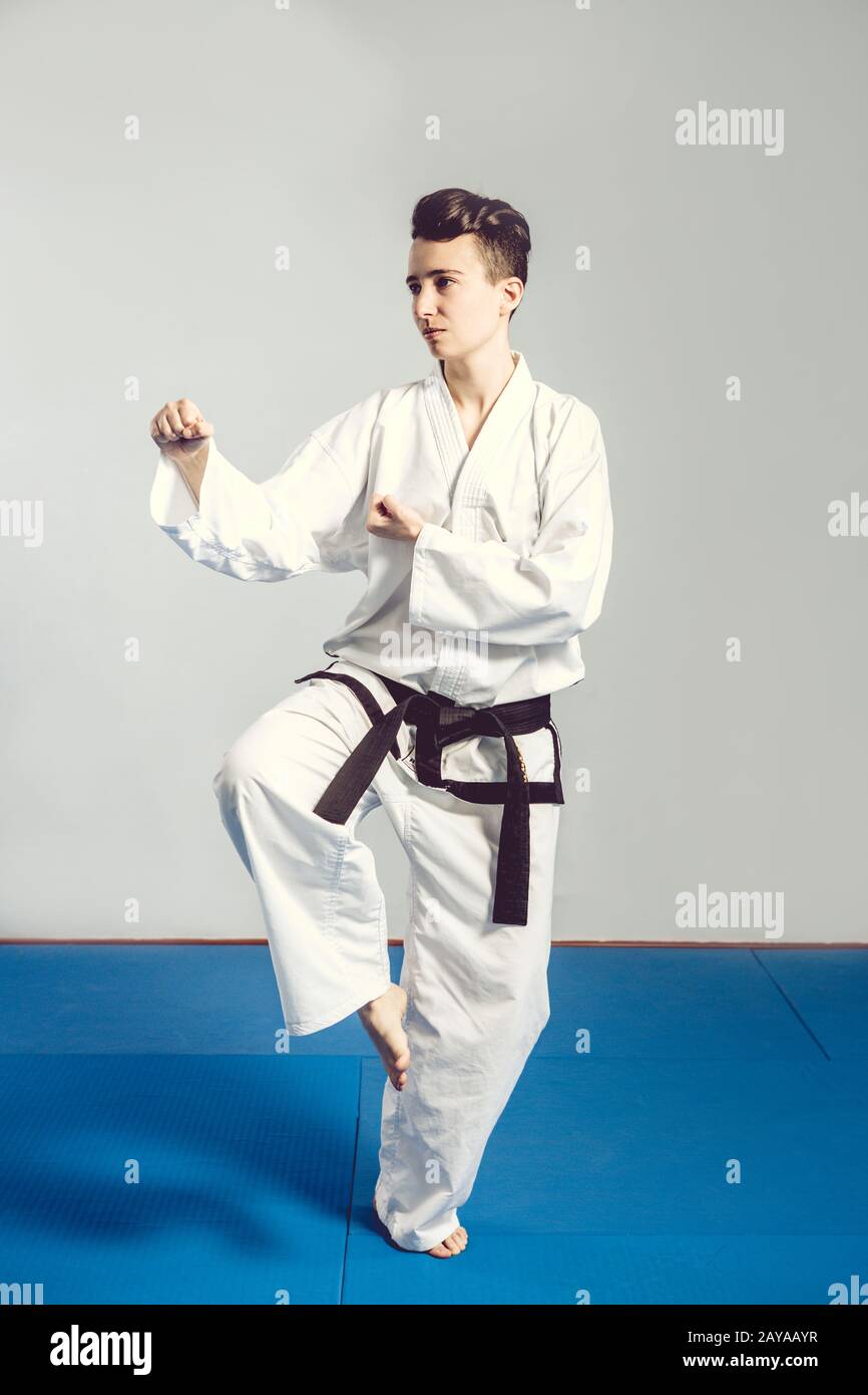 girl in karate suit kimono in studio at grey background. Female child ...