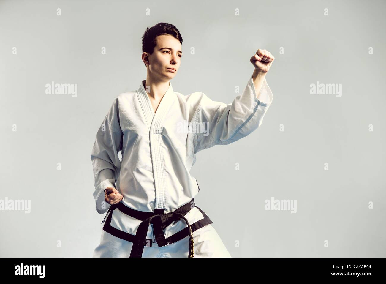girl in karate suit kimono in studio at grey background. Female child ...