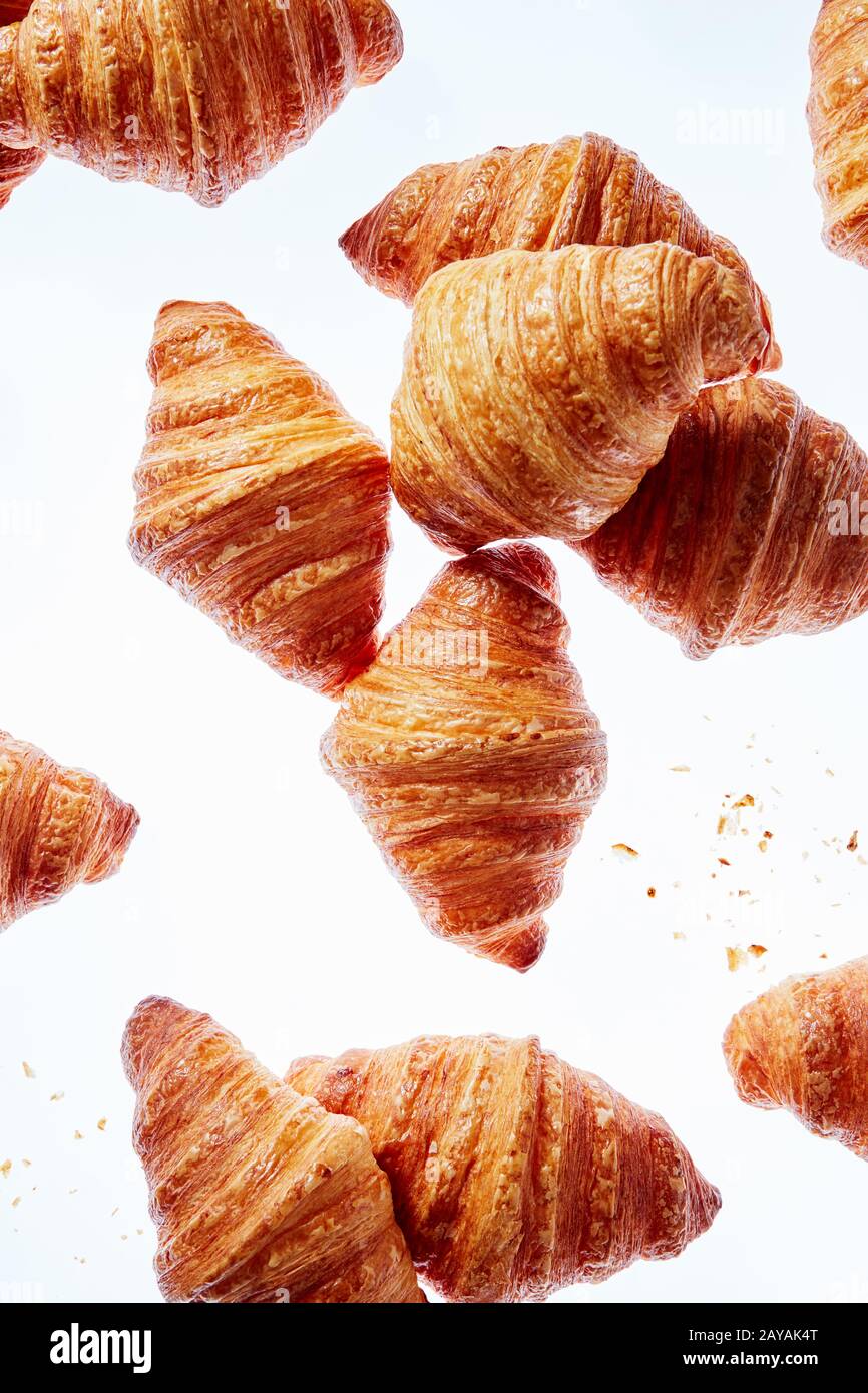 Falling fresh french croissants with crumbs on a light background Stock ...
