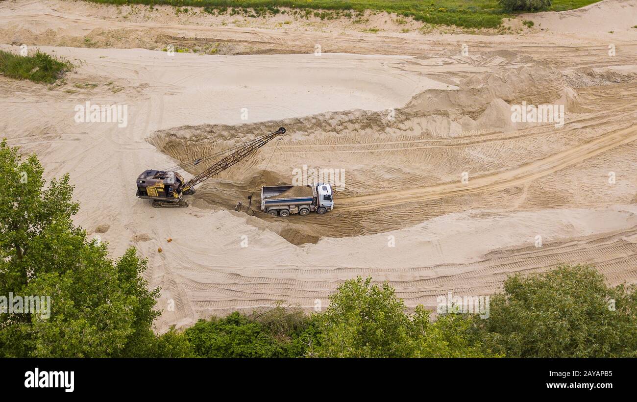 Tod down view of excavator loading dump truck. On the construction site ...