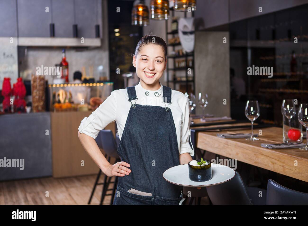 young girl with a beautiful smile a waiter holds in her hands an order ...