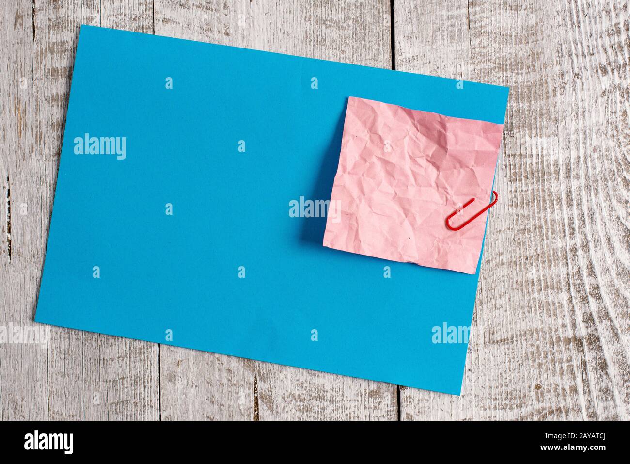 Crumpled note paper and blank cardboard above wooden table. Wrinkle ...