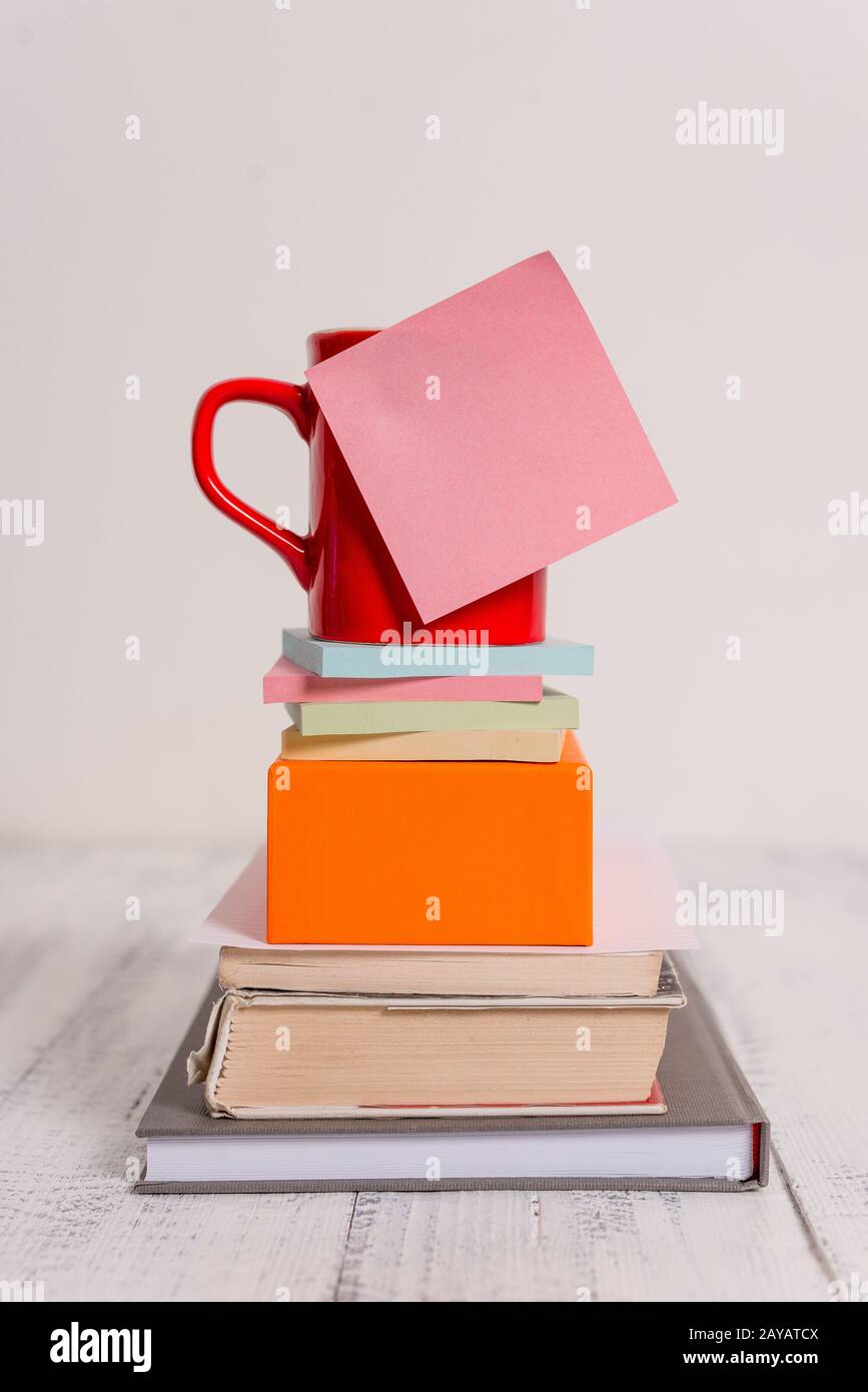 Front view coffee cup blank colored sticky note stacked note pads books ...