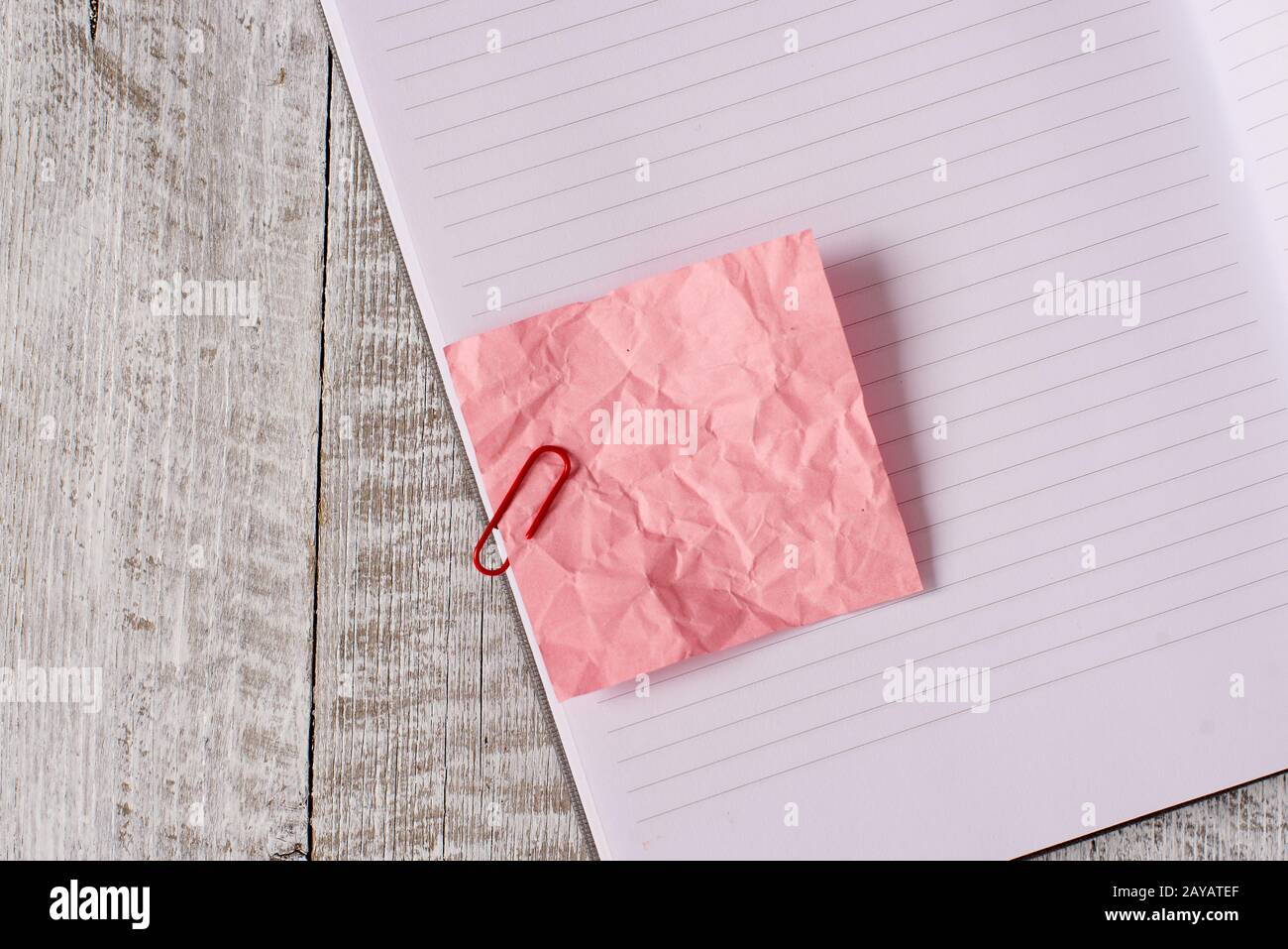 Crumpled note paper and a notebook placed above wooden table. Wrinkle ...