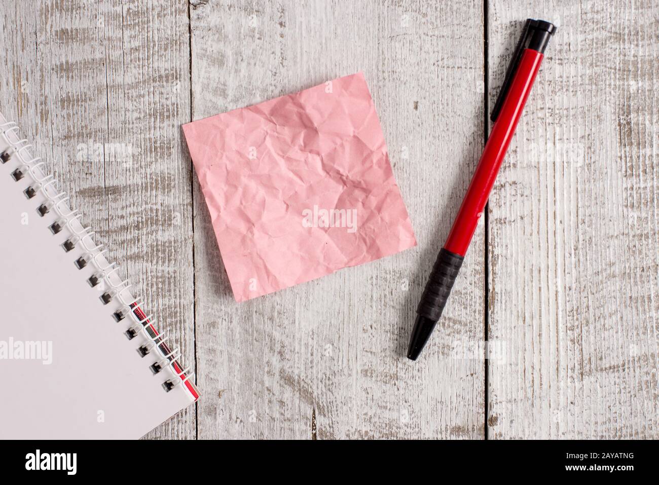 Crumpled note paper and a notebook placed above wooden table. Wrinkle ...
