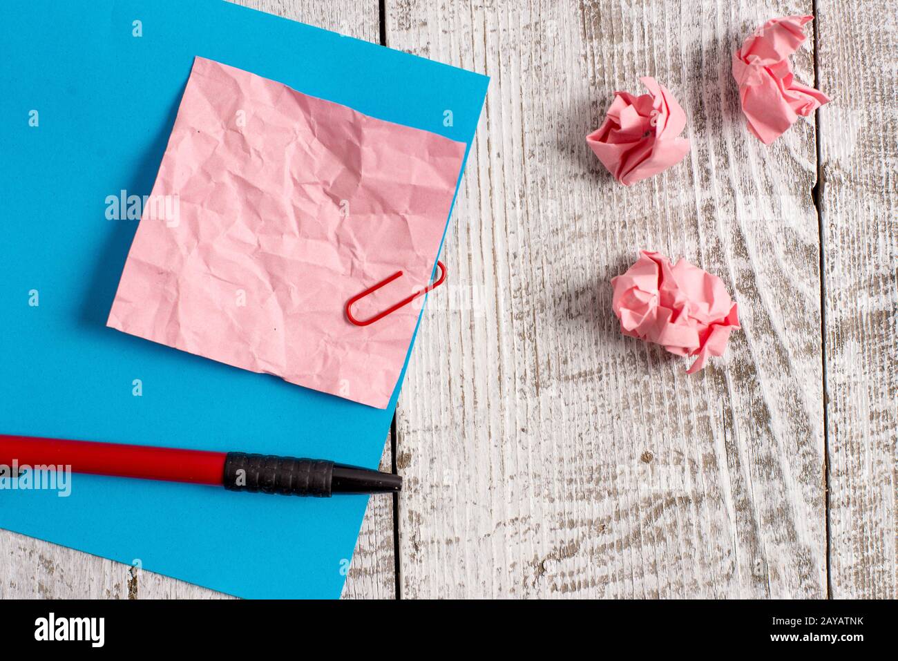 Crumpled note paper and blank cardboard above wooden table. Wrinkle ...