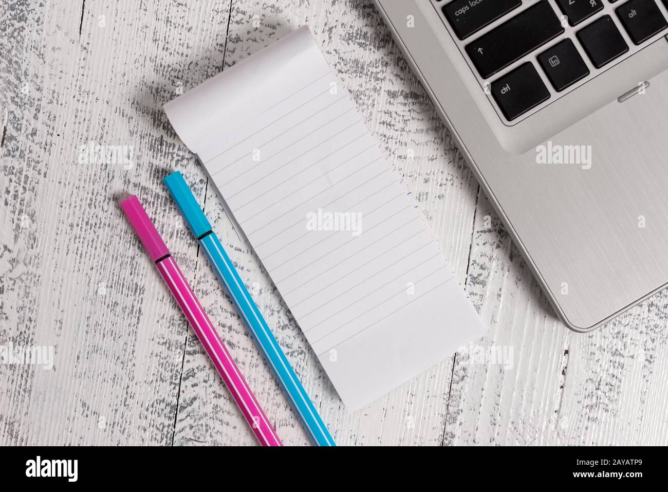Trendy metallic laptop ruled notepad pens lying wooden rustic vintage ...