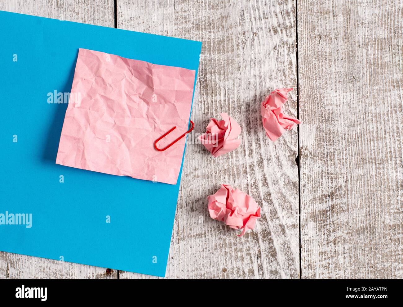 Crumpled note paper and blank cardboard above wooden table. Wrinkle ...