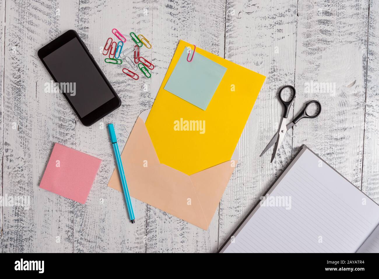 Open colored envelope blank sheet paper sticky notes ballpoint clips ...