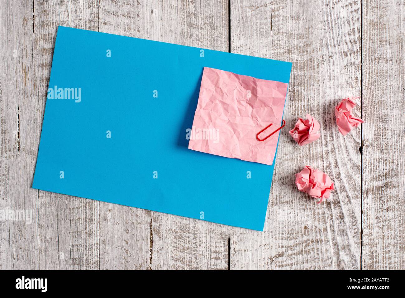 Crumpled note paper and blank cardboard above wooden table. Wrinkle ...