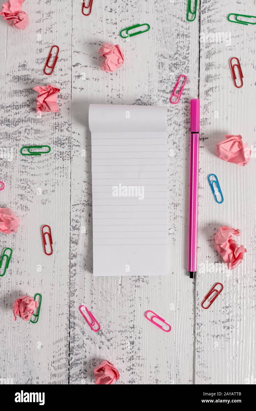 Stripped ruled notepad clips crushed paper balls pen lying wooden retro ...