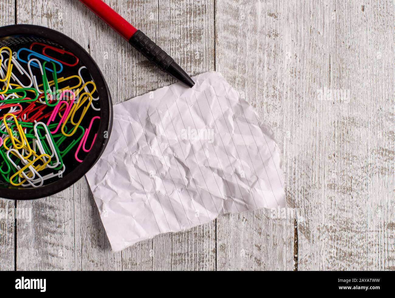 Crumpled note paper and clips placed above wooden table. Wrinkle sheet ...