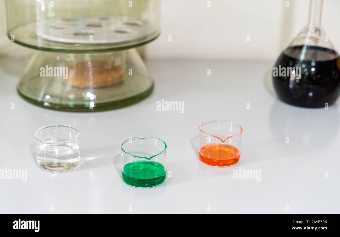 Colourful chemical liquid solutions in glass flasks on white laboratory ...