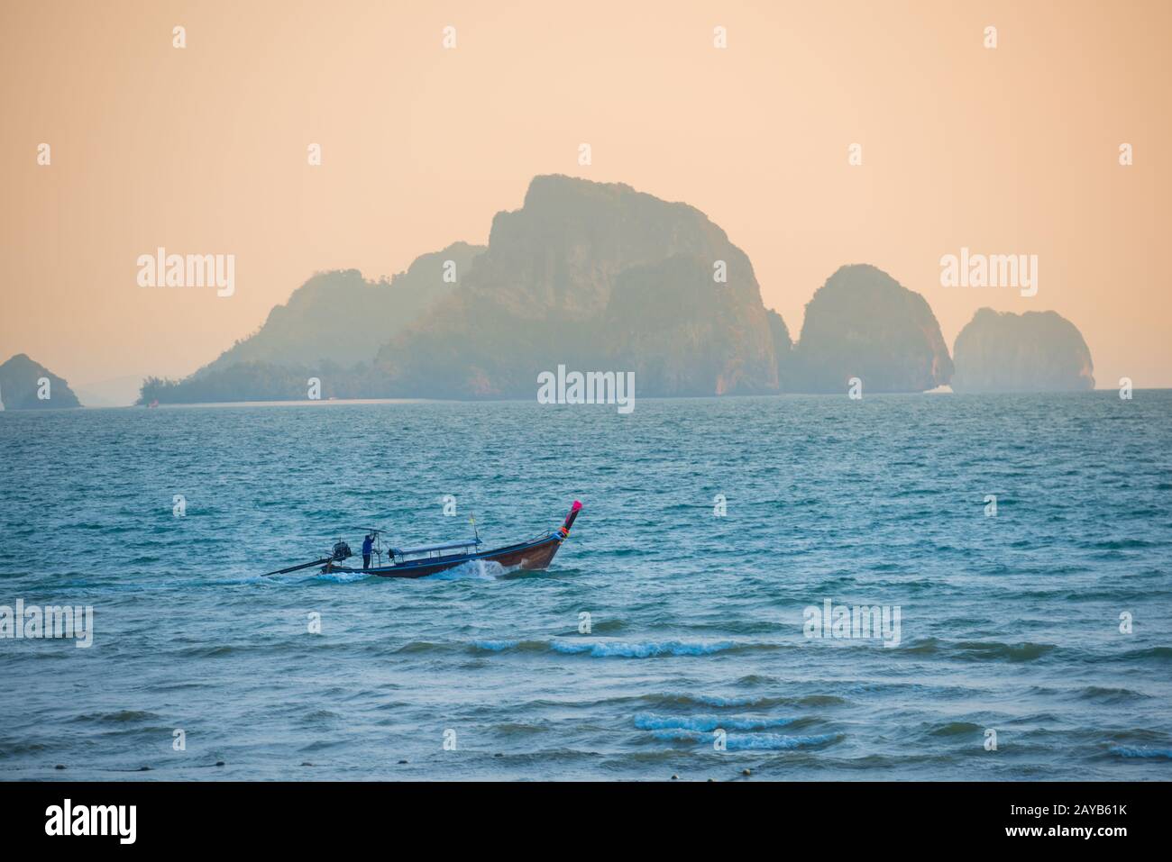 Traditional boat in tropical sea with rock island Stock Photo - Alamy