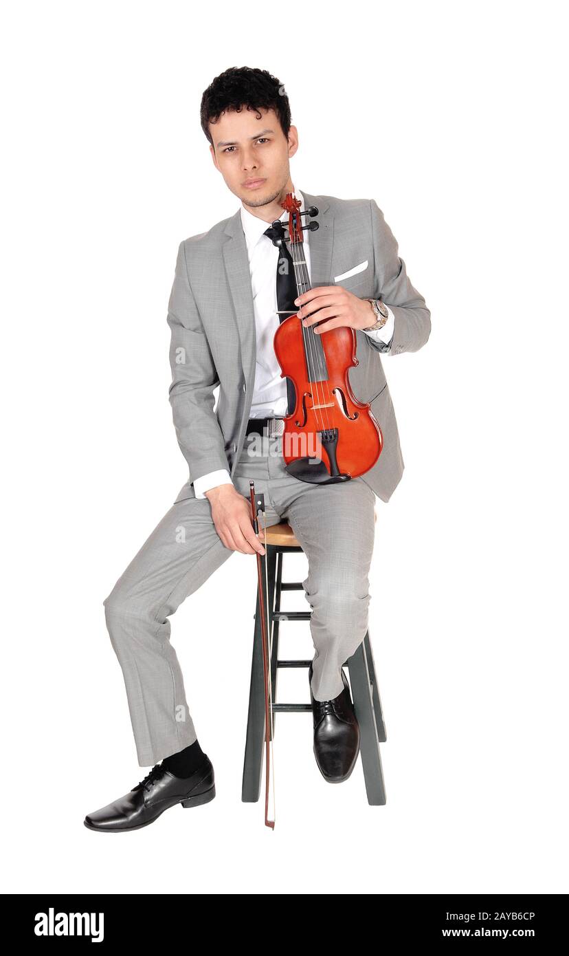 Young man sitting with his violin in his hands Stock Photo - Alamy