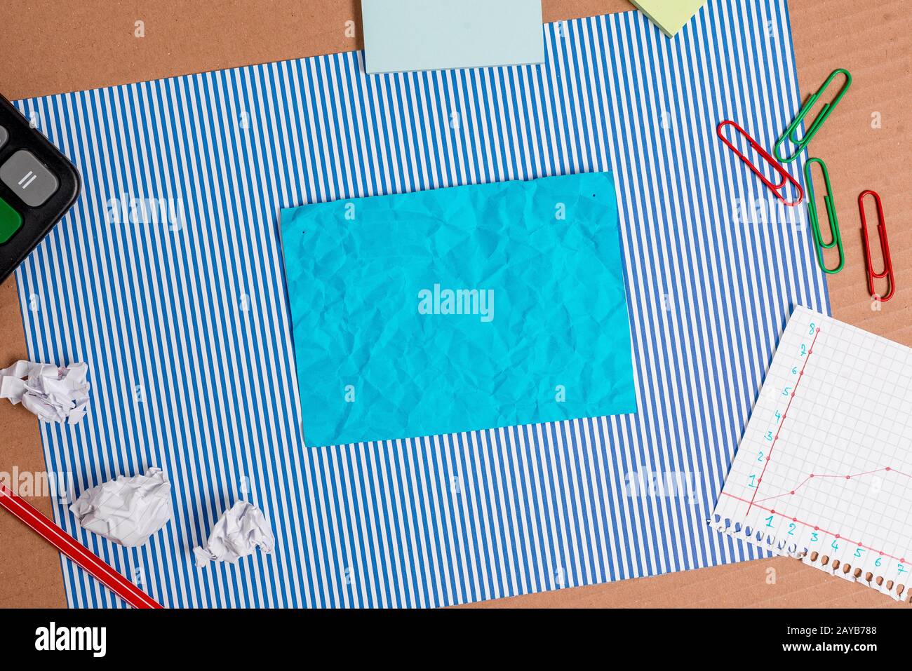Cardboard desk with a striped blue sheet, notebook paper and office ...